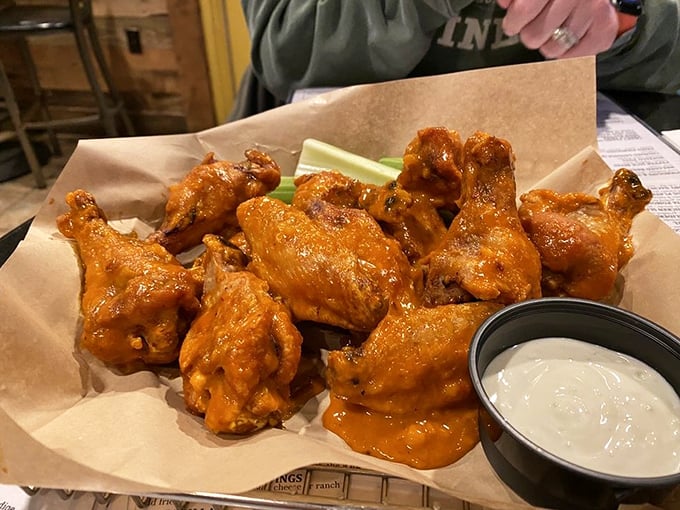 These wings don't fly—they soar straight into flavor heaven, their bright orange coating a warning sign that delicious heat lies ahead.