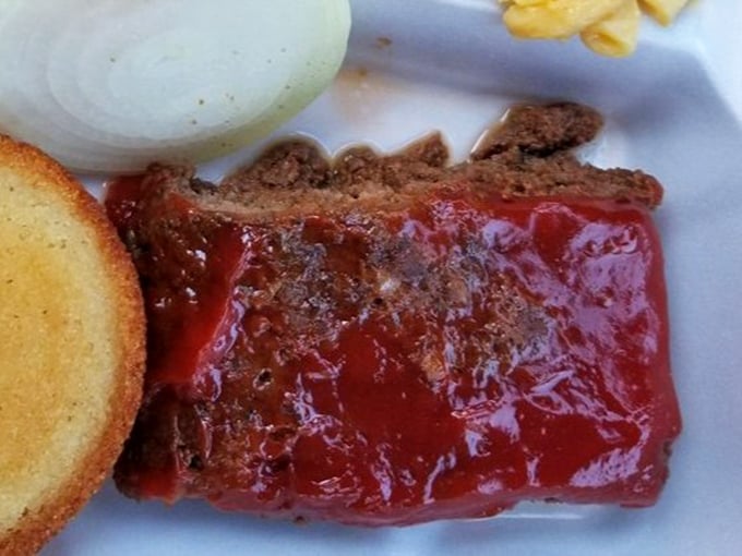 Meatloaf glazed with tangy sauce sits alongside cornbread and sides – a plate that whispers "comfort" in the universal language of home cooking.
