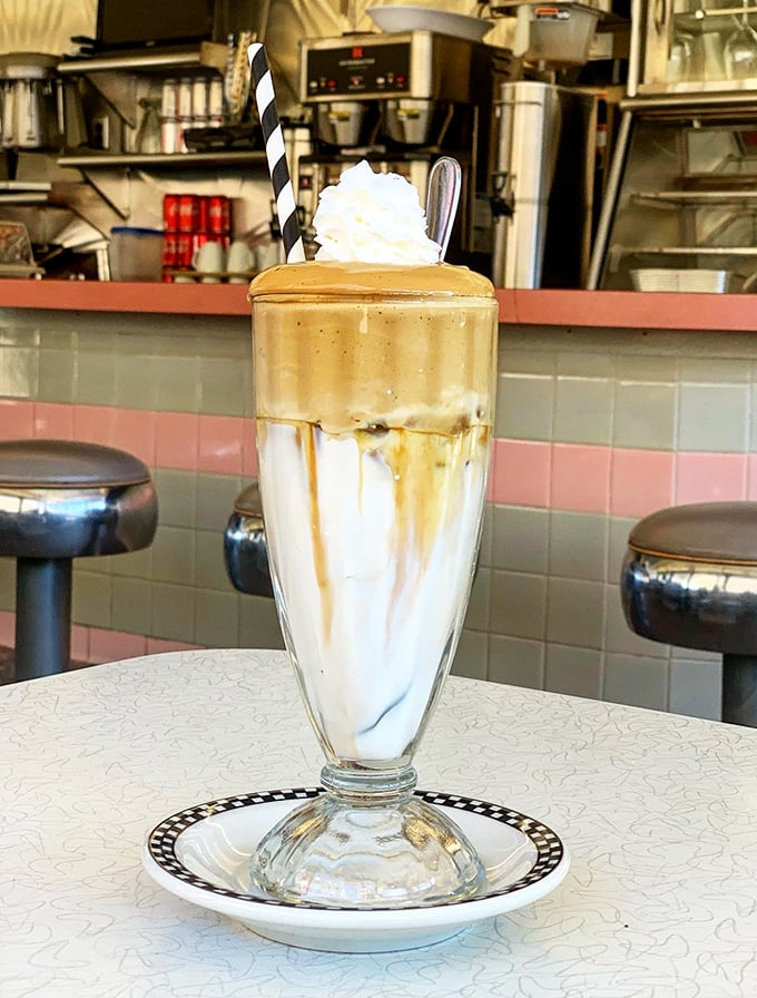 This isn't just a milkshake – it's a frothy tower of nostalgia served in a glass tall enough to house your childhood dreams.