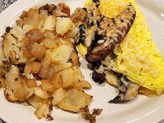 This mushroom and cheese omelet performs the perfect breakfast balancing act—fluffy eggs, savory fillings, and those home fries that deserve their own fan club.