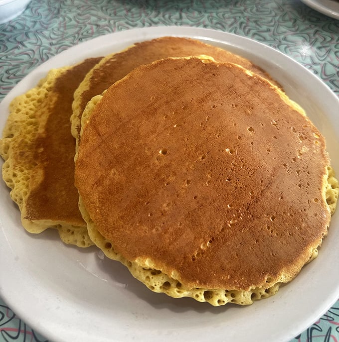 Pancakes so perfectly golden they look like they've been sunbathing in butter. These aren't just breakfast—they're edible sunshine.