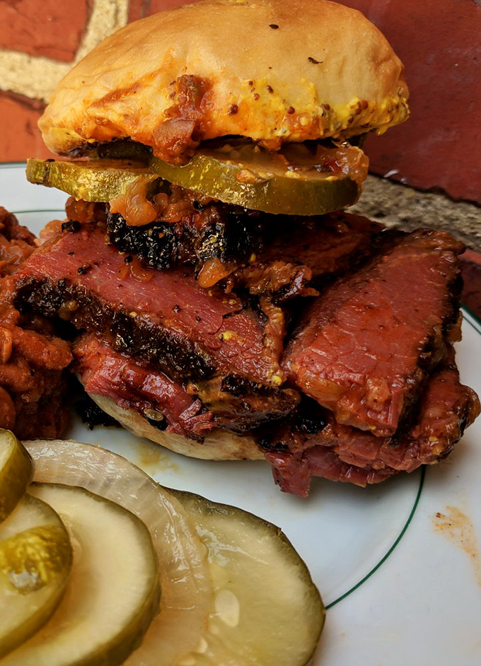 This isn't just a sandwich—it's architecture. Layers of pastrami and pickles create a skyscraper of flavor that would make any New York deli jealous.