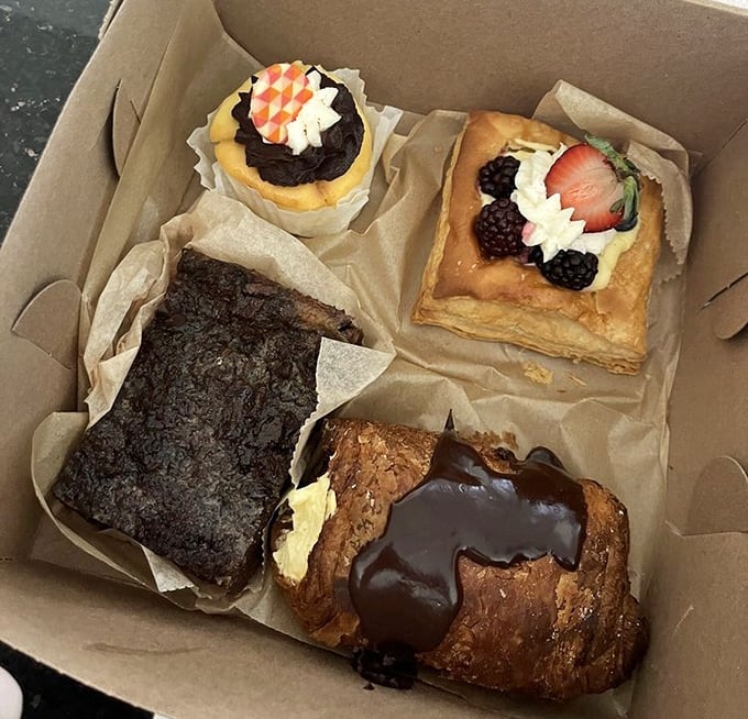 The bakery box—nature's most perfect delivery system for happiness. Each pastry sits like a jewel in a treasure chest.