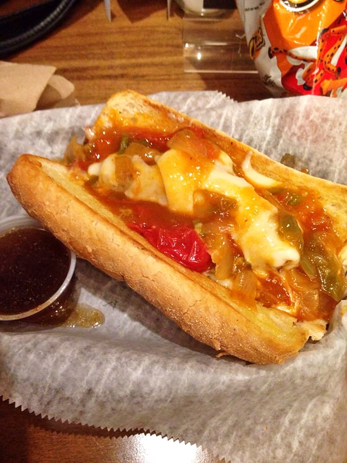 The hand applying that final touch of celery salt – the culinary equivalent of a painter signing a masterpiece. Chicago dog perfection!