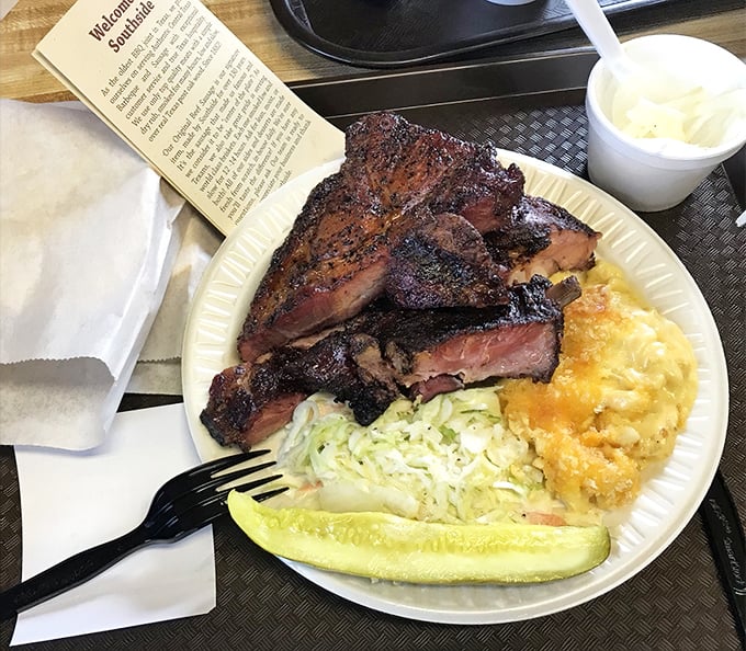 A plate that speaks the universal language of Texas – smoked meat, mac and cheese, coleslaw, and a pickle spear for that perfect acidic counterpoint.