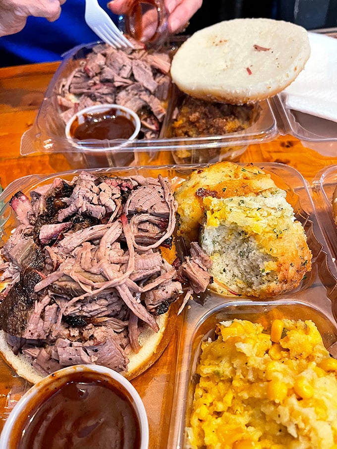 This pulled pork sandwich with cornbread and mac and cheese is what comfort food dreams are made of. The sauce cup is standing by like a faithful sidekick.