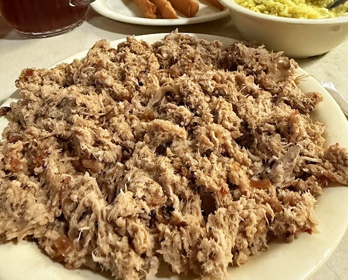 Eastern-style chopped pork in its natural habitat—piled high on a simple white plate. No fancy garnishes needed when the smoke has been doing all the talking.