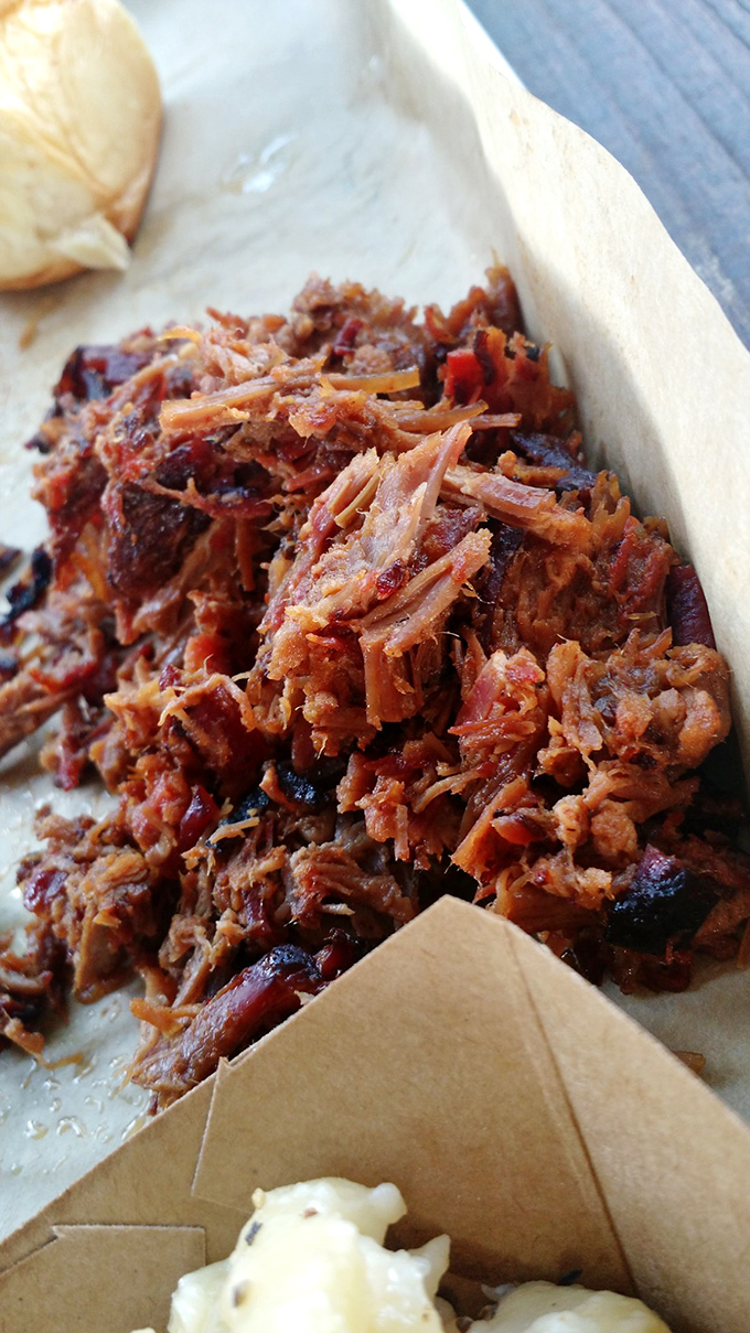 This pulled pork doesn't just fall apart—it practically disintegrates with a gentle nudge, revealing strands of smoky perfection ready for their close-up.