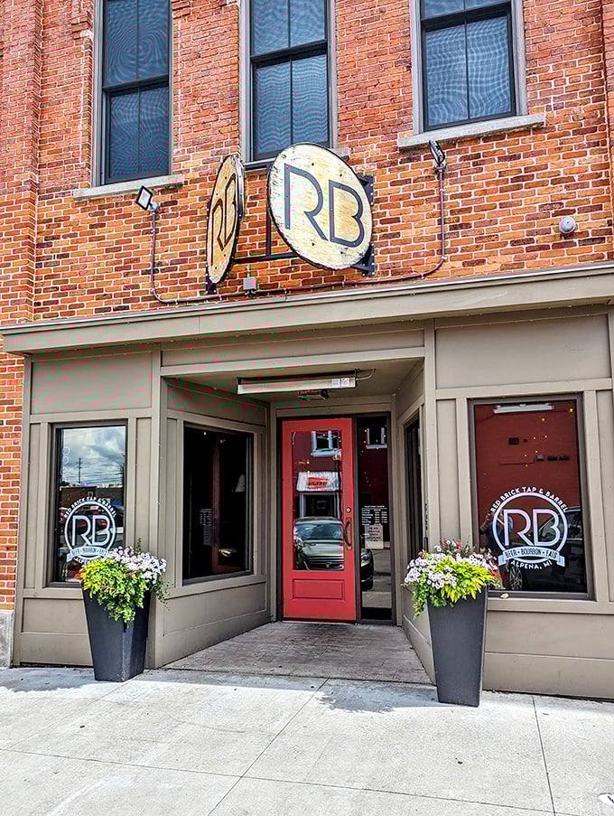 The Red Brick Tap & Barrel welcomes visitors with its warm red door and flourishing planters—the universal signal for "good times and local brews inside."