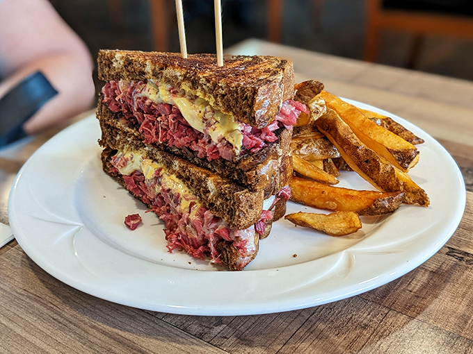 The Reuben sandwich here isn't messing around—look at that glorious stack of corned beef and melted cheese that's practically bursting from its toasty prison.