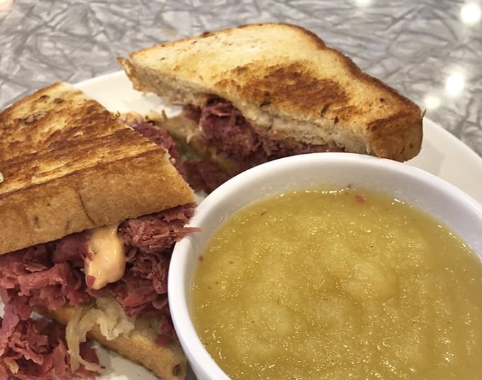 The Reuben—where corned beef meets sauerkraut in a dance as old as time, with a side of applesauce playing chaperone.