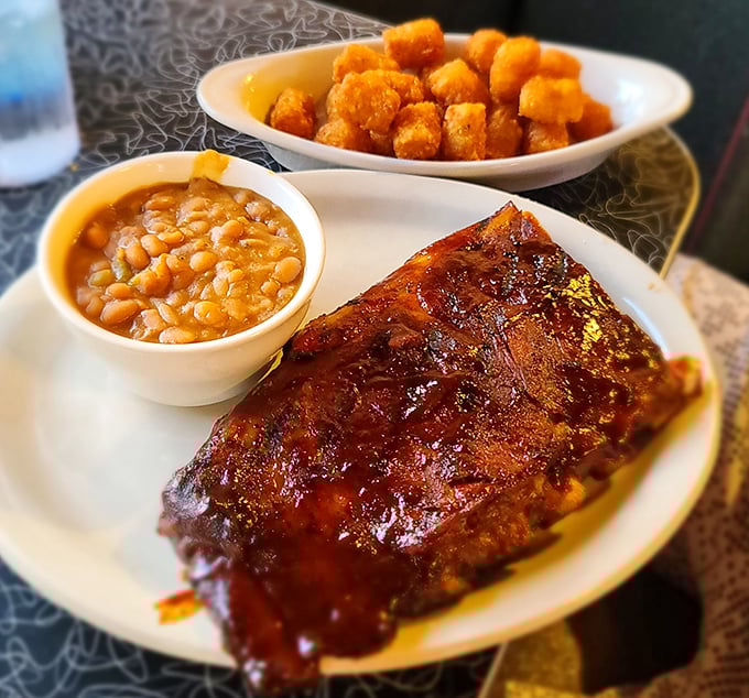 Glistening ribs with that perfect smoke ring, flanked by baked beans and tater tots—a trio that makes carnivores weak at the knees.
