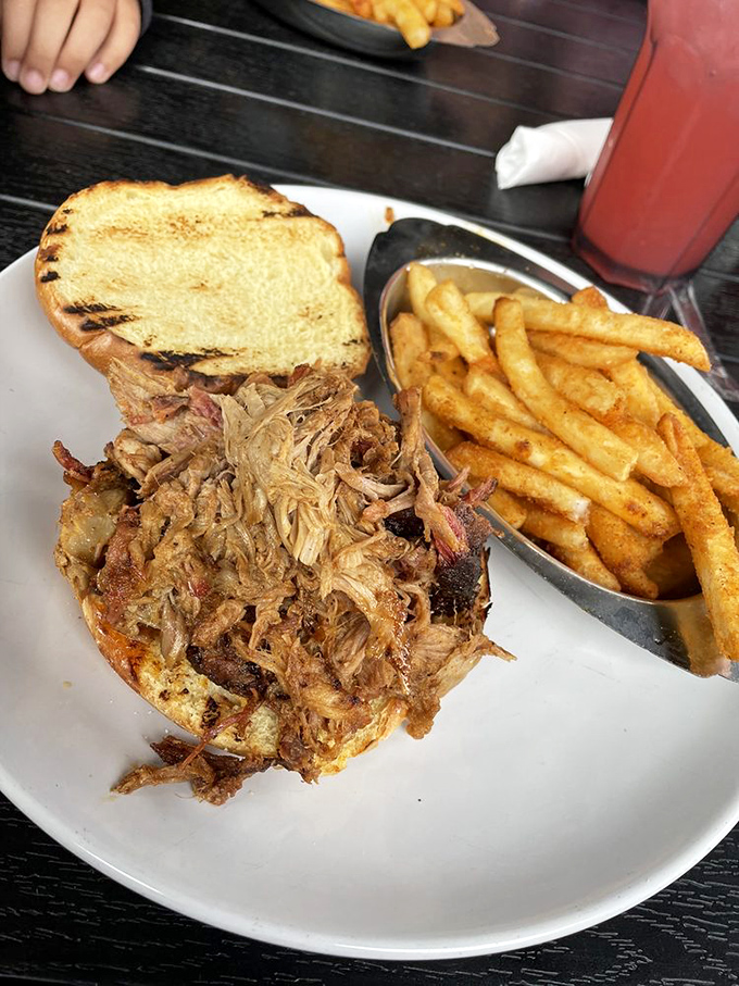 This pulled pork sandwich isn't just a meal—it's an architectural marvel of tender meat and toasted bread that demands to be photographed before devoured.
