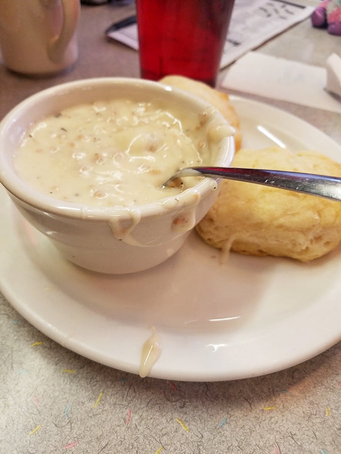 A bowl of creamy sausage gravy alongside a fresh-baked biscuit—the kind of breakfast that makes you want to hug the cook.