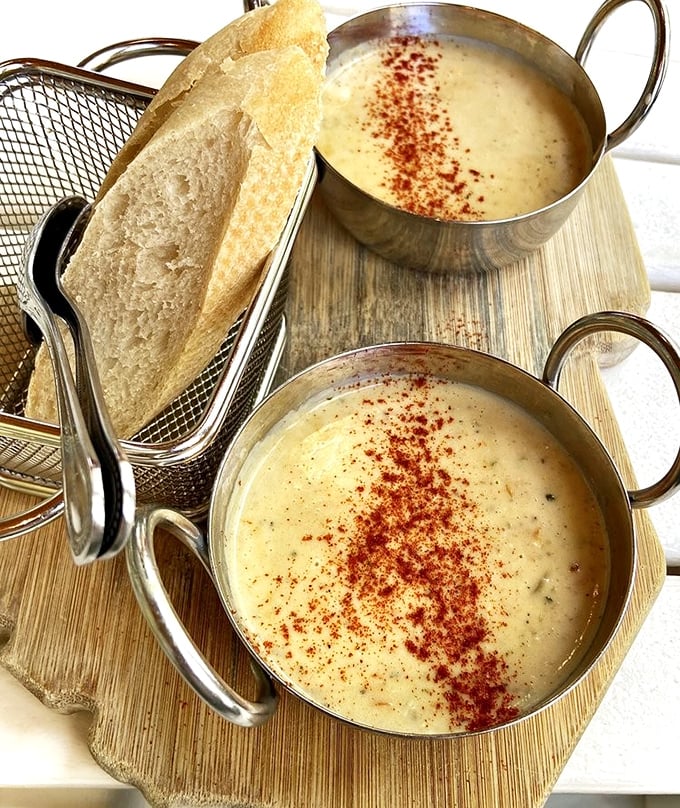 She-crab soup served with style—velvety, rich, and topped with a sprinkle of paprika. The bread basket is just a vehicle for sopping up every last drop.