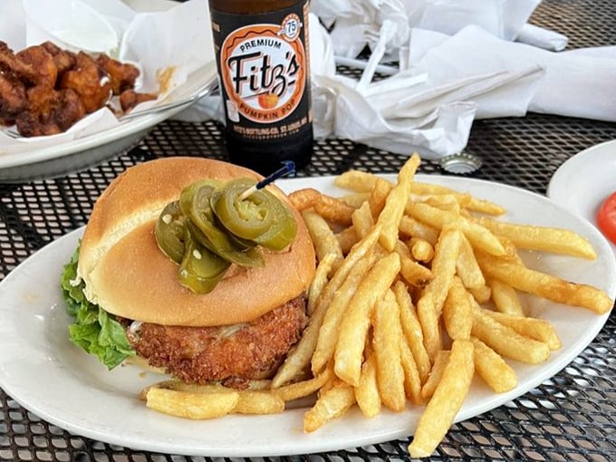 Jalapeños perched atop this burger like tiny green sentinels guarding flavor territory. The pickle spears are just showing off at this point.
