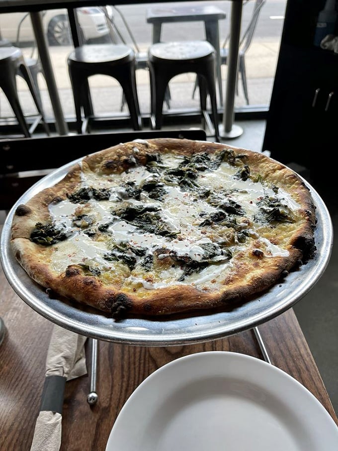 A white pizza that whispers rather than shouts, letting spinach take center stage. Like a good jazz solo, it's all about what's not there.