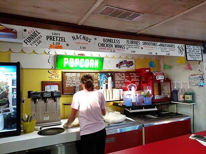 The glowing green "POPCORN" sign beckons like a lighthouse, guiding hungry moviegoers to buttery, salty salvation.