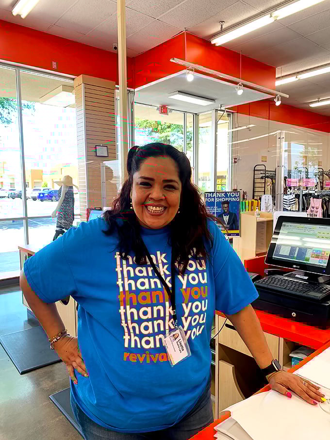 The image shows a staff member at the checkout counter with a welcoming smile.