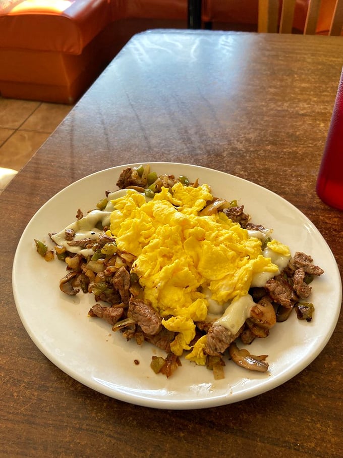 A breakfast skillet that means business – eggs lounging atop a bed of meat and vegetables like they're sunbathing on a Florida beach.