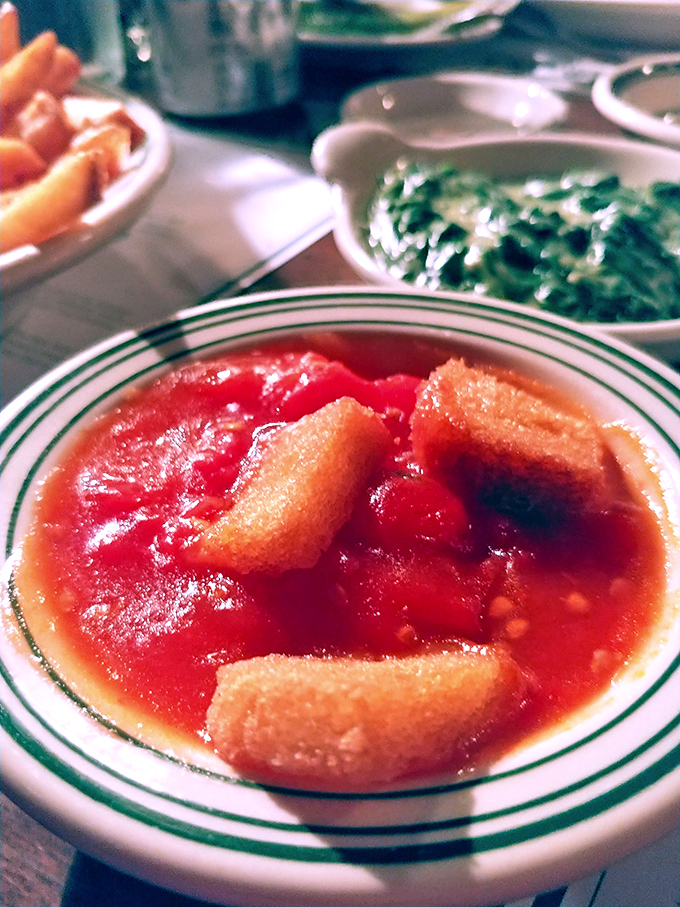 Stewed tomatoes with bread cubes – the side dish your grandmother would approve of, swimming in a bright red bath of nostalgia.