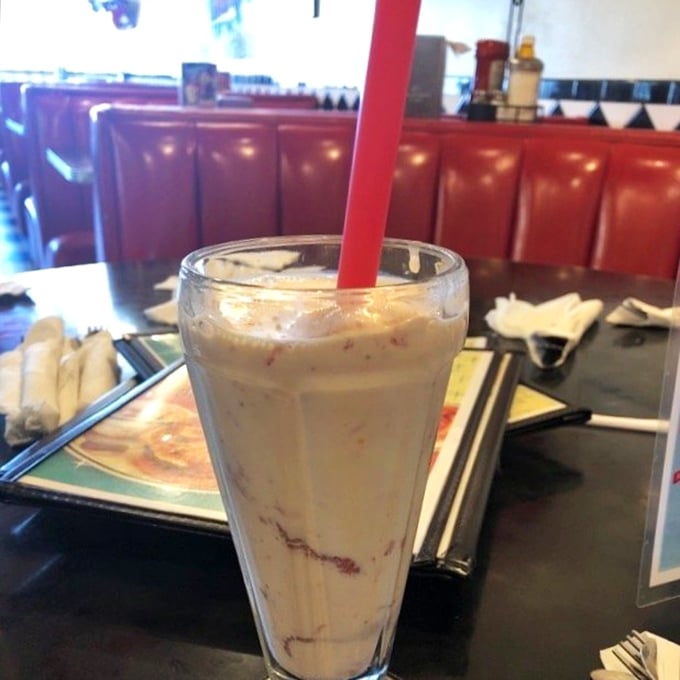 This isn't just a milkshake—it's a commitment. That red straw stands ready for the delicious challenge ahead, while those swirls promise strawberry bliss in every sip.