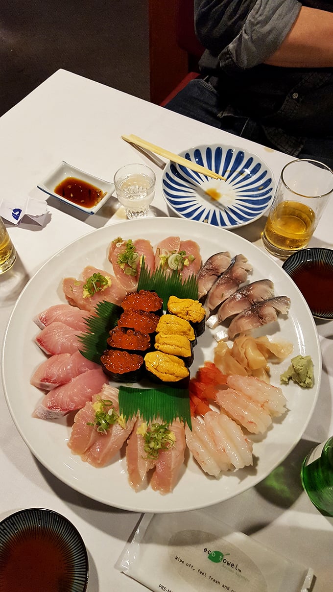 Sushi as art form—a pristine plate where vibrant uni meets glistening fish, arranged with the precision of a Japanese garden.