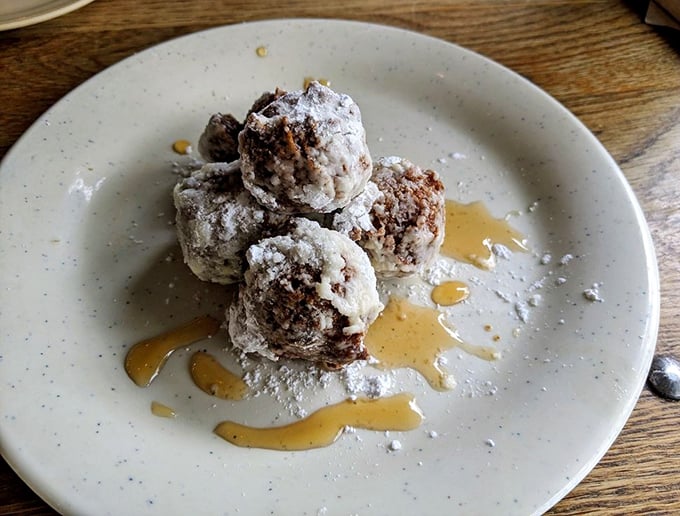 Sweet potato beignets drizzled with maple syrup—proof that vegetables can have exciting second careers as dessert. These little spheres of joy demand attention.