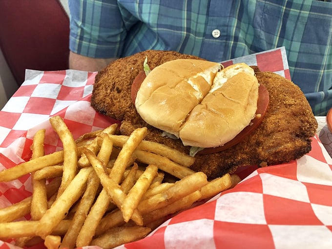 The tenderloin sandwich – where the meat rebelliously refuses to acknowledge the boundaries of its bun. Paired with fries that demand equal attention.