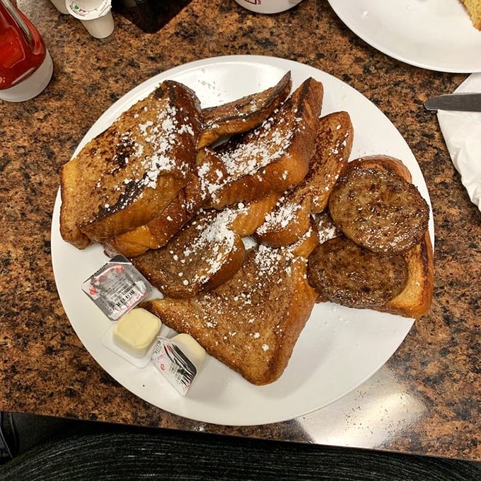 French toast that would make a Parisian jealous—golden-brown, dusted with powdered sugar, and generous enough to share (though you probably won't want to).