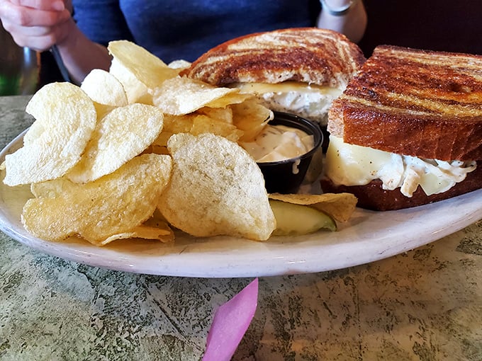 The perfect lunch combo: a golden-grilled sandwich with potato chips that crackle with each bite—simple pleasures at their finest.