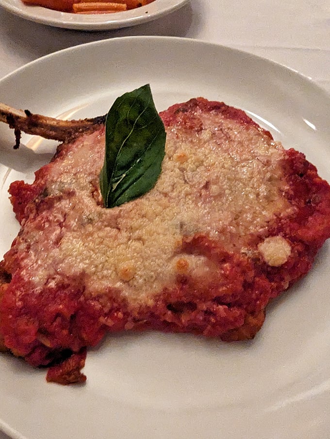 Veal parmigiano with a single basil leaf standing guard—simple, classic, and utterly incapable of disappointing anyone with taste buds.