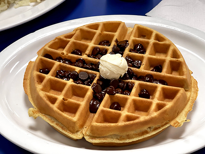 Waffle perfection is mathematical: golden squares filled with blueberries and topped with a dollop of butter slowly surrendering to the warmth.