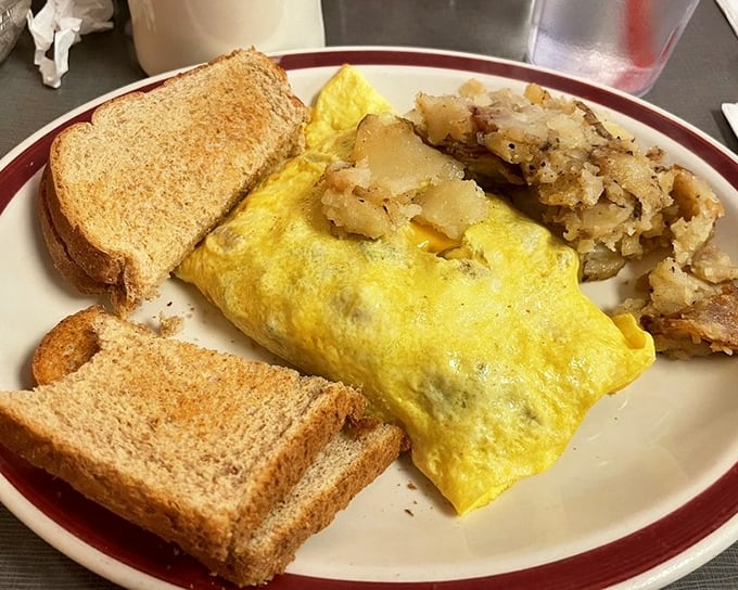 The Western omelet—where eggs meet their destiny alongside perfectly crisped hash browns and toast waiting for its butter bath.