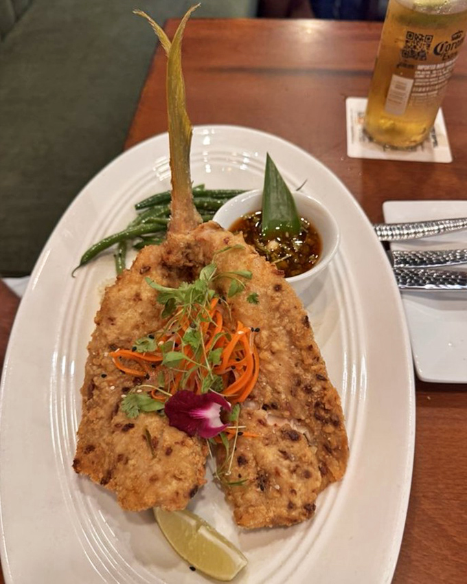 Crispy yellowtail presented with artistic flair and a side of green beans. The edible orchid isn't just pretty—it's a promise of excellence.
