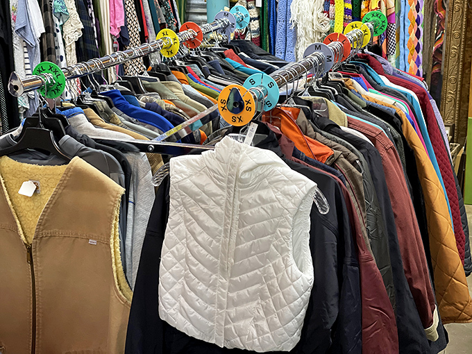 Color-coded clothing racks create a rainbow road map to style reinvention, where your next signature look is hiding between someone else's castoffs.