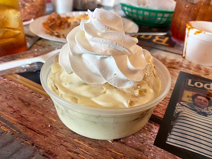 The legendary banana pudding arrives crowned with a cloud of meringue—heaven in a plastic cup that's worth every single calorie.