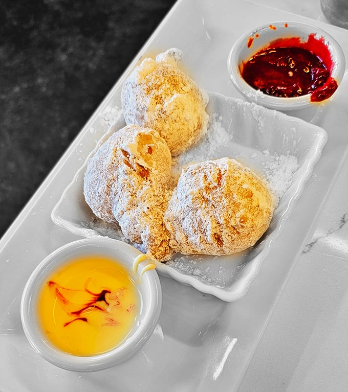 These beignets aren't just donut cousins—they're powdered pillows of happiness served with honey and berry compote for that perfect sweet-tart balance.