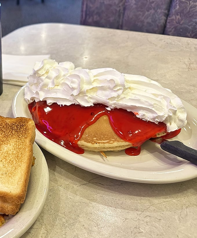 These pancakes aren't just topped with strawberry glaze—they're wearing a red carpet outfit. The whipped cream is just showing off at this point.