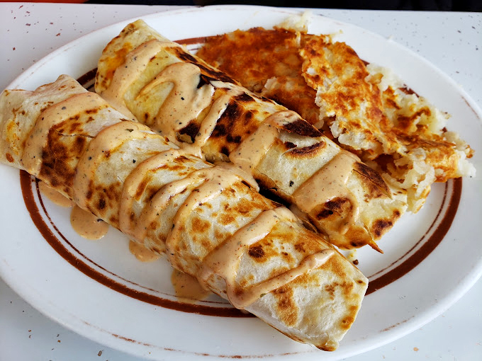 The breakfast burrito: where eggs, sausage, and cheese find their higher purpose, wrapped in a tortilla and baptized with ranchero sauce.