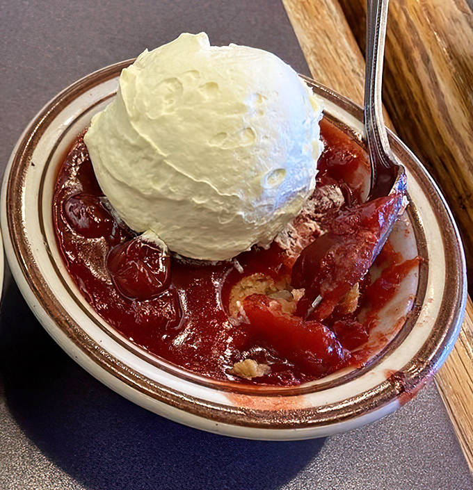Cherry cobbler crowned with vanilla ice cream—the kind of dessert that makes you consider skipping the main course next time.