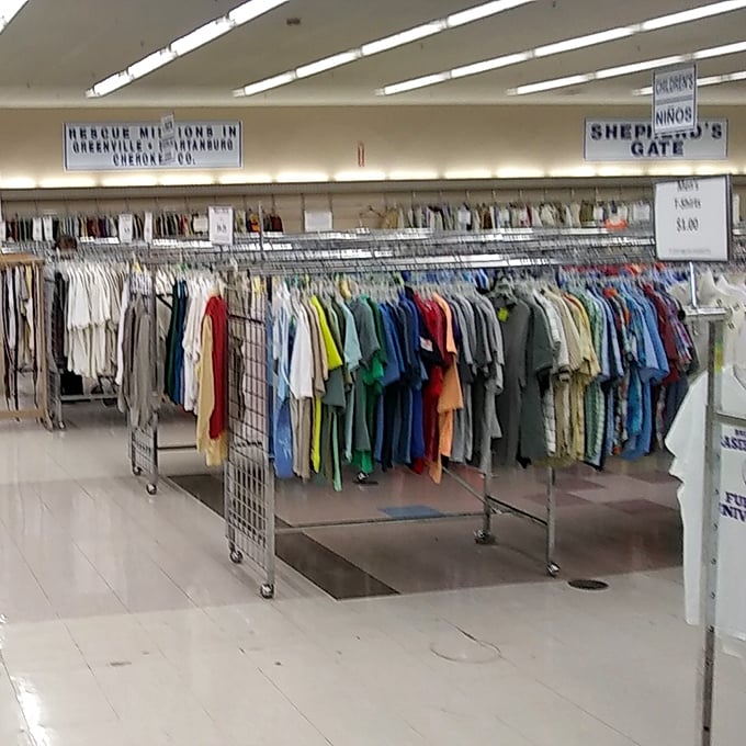 Signs overhead remind shoppers their purchases support real community programs. These aren't just clothes—they're second chances hanging neatly by color and size.