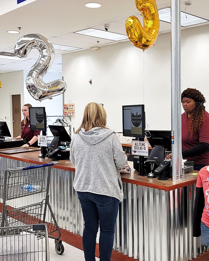 The checkout counter where treasures become yours – those balloons suggest someone's celebrating the thrift store's anniversary or special sale event.