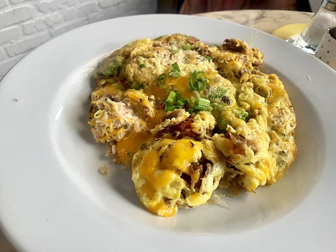 Comfort food elevated to art form. Melted cheese cascades over what appears to be a hearty egg dish—proof that breakfast knows no boundaries here.