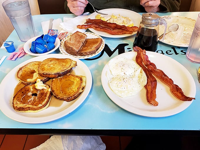 The full breakfast spread – golden pancakes, crispy bacon, and eggs that would make a rooster proud. This is why alarm clocks were invented.