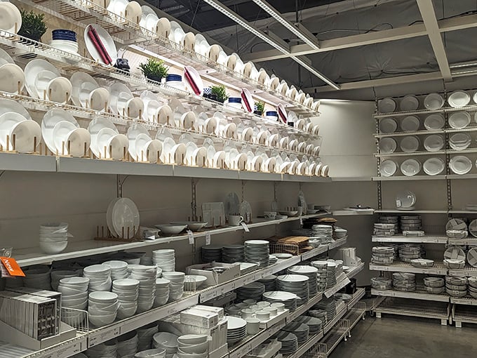 The white plate wall at HomeGoods—where dinner party dreams are born and credit cards go to die, one perfectly affordable serving dish at a time.