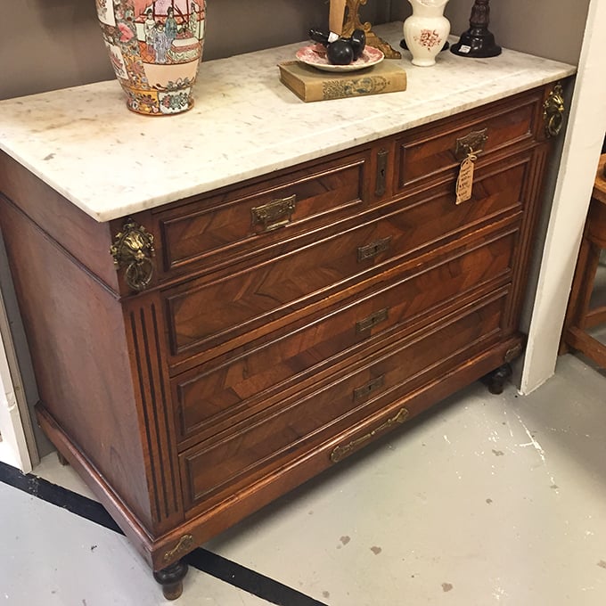 This marble-topped dresser with intricate woodwork isn't just furniture—it's functional architecture that's survived longer than most relationships.