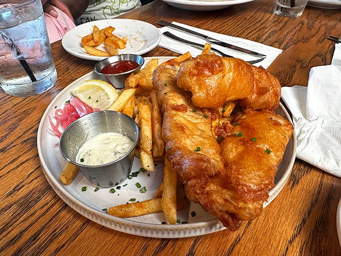 Fish and chips that would make a British pub regular weep with joy—golden-battered perfection alongside fries that demand to be savored.