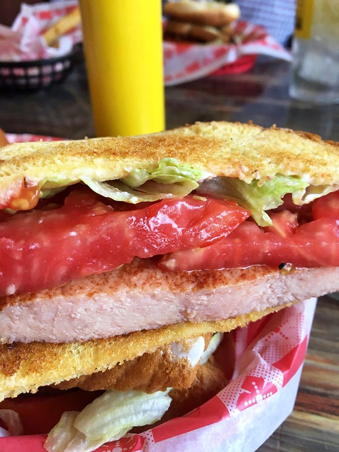 The famous fried bologna sandwich—thick-cut, perfectly grilled, with those caramelized edges that transform a humble lunch meat into a culinary rockstar.