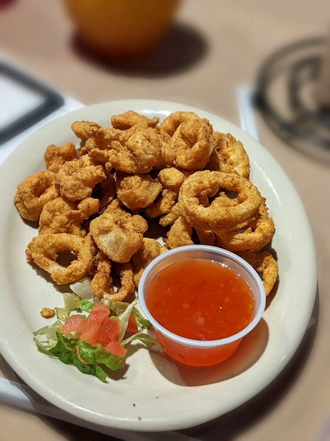 Crispy calamari rings piled high like delicious golden halos, with that perfect dipping sauce standing by. Ocean-to-table magic in the heartland.